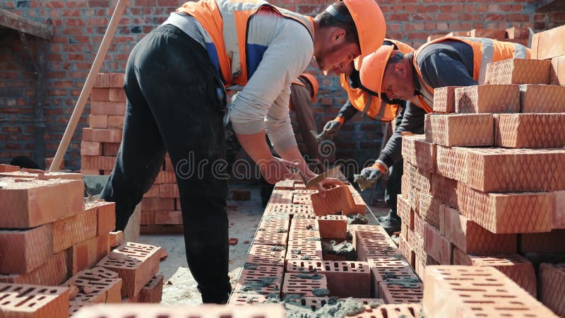 Builders Building a Brick Wall. Construction Work on Construction Stock ...