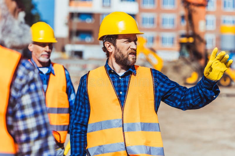 Builders Discussing Work while Standing Stock Photo - Image of teamwork ...