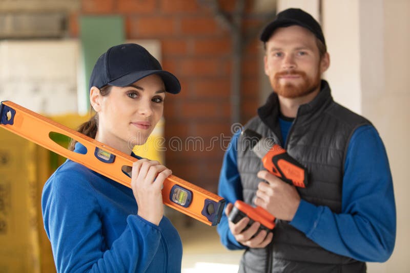 Builders with Drill and Spirit Level Stock Image - Image of female ...