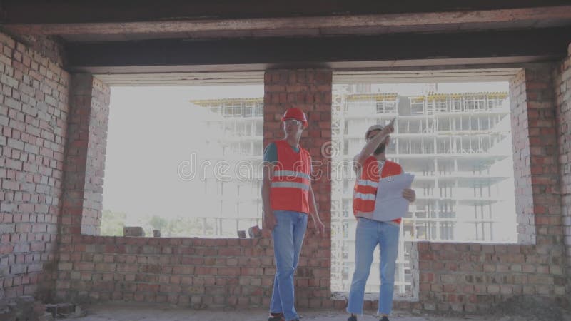 Builders Inside a New Building. Engineers with a Blueprint Inside a New ...