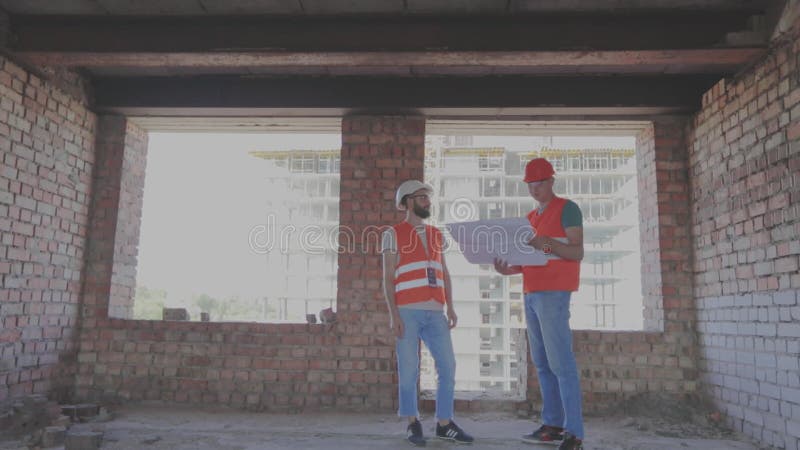 Builders Inside a New Building. Engineers with a Blueprint Inside a New ...