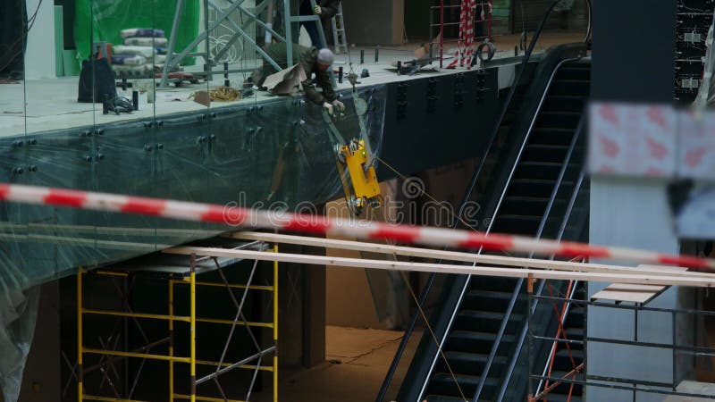 The Builders are Lifting a Glass Load Onto a Construction Site that is ...