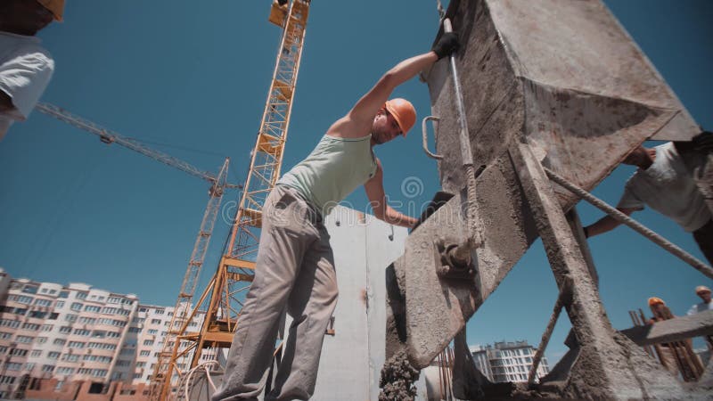 Builders Move a Container with Concrete and Pour it on the Construction ...