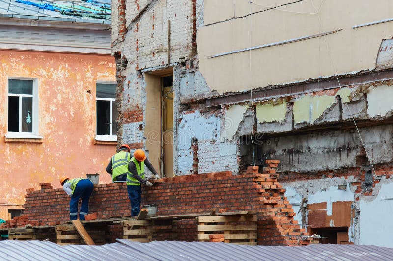Builders in Overalls and Hard Hats Laying Red Bricks at a Construction ...