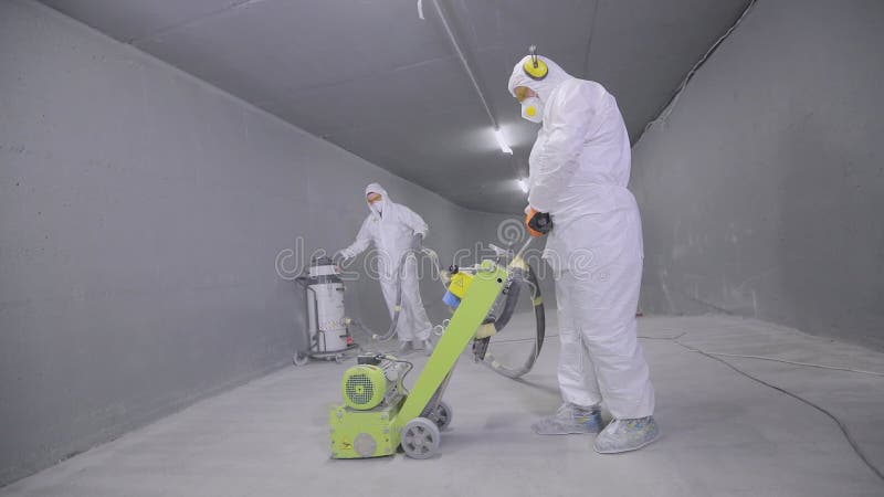 Concrete Surface Grinding. Builders at a Construction Site. Builders ...