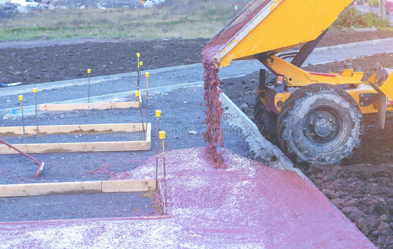 Builders Pouring and Levelling Wet Ready-mix Concrete into Formwork ...