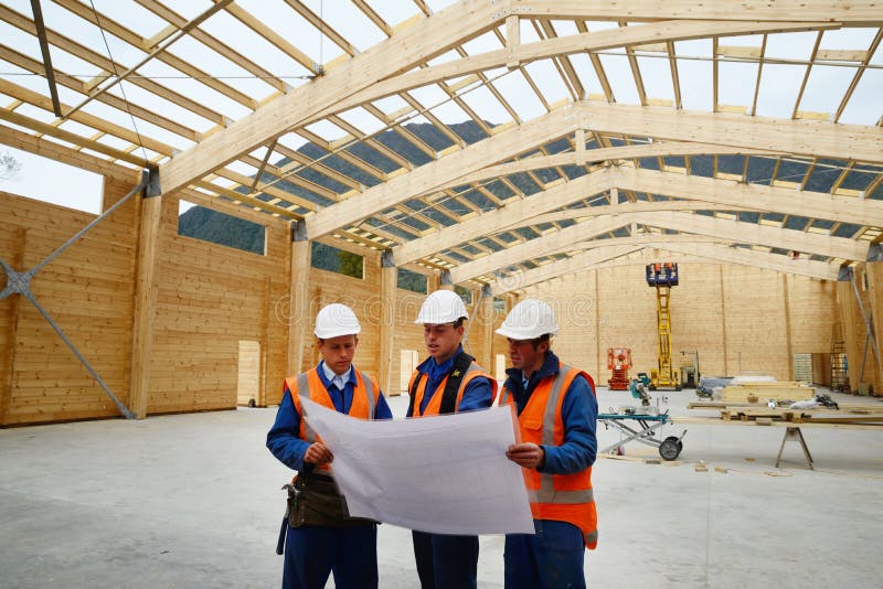 Builders study the plan stock image. Image of helmet - 48608357