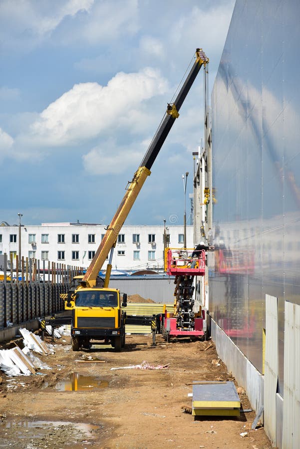 Builders Work at a Construction Site with a Cradle of a Tower Crane ...