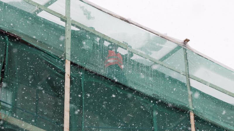 Builders Workers Stand on Construction Scaffolding and Throw Snow from ... Builders Workers Stand on Construction Scaffolding and Throw Snow from ...