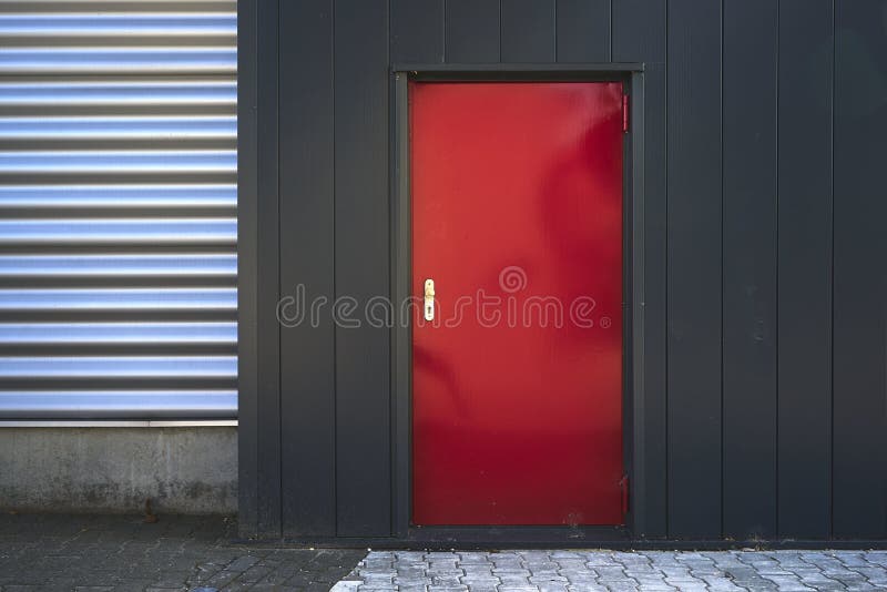 Building with Black and Silver Walls and a Red Door on the Pavement ...