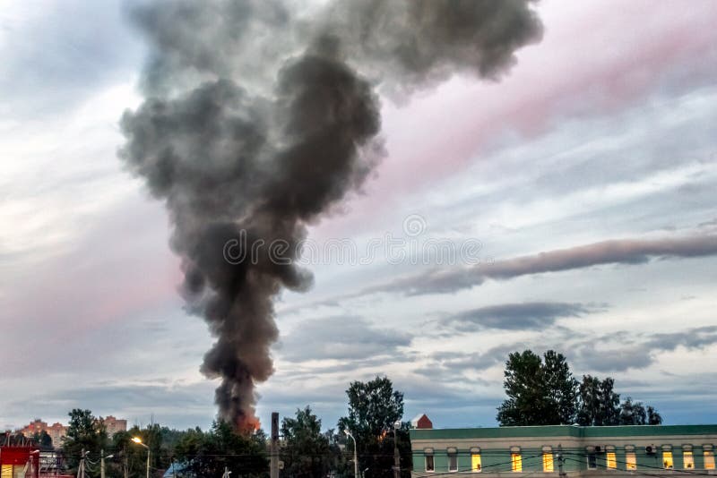 The Building Burns with Fire and Black Smoke Against the Evening Sky ...