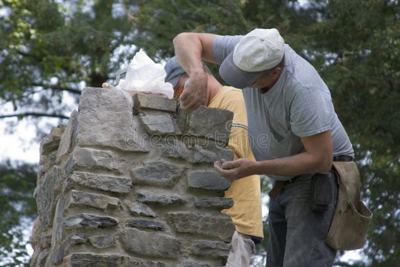 Man building stone wall stock image. Image of garden - 17735239