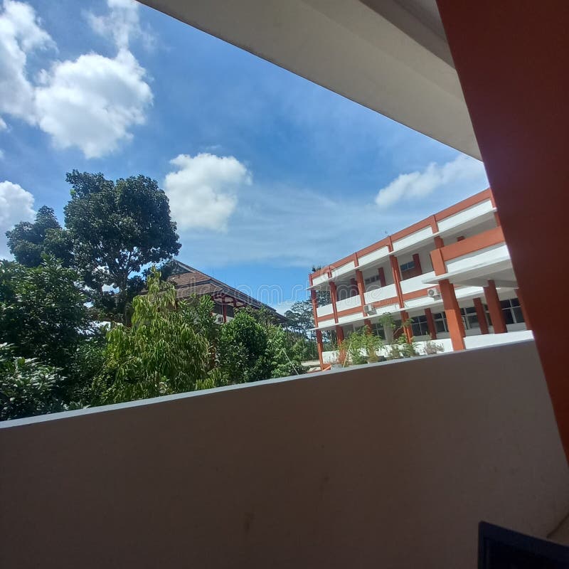 Building with Cloud, Sunlight, and Trees from Below Stock Photo - Image ...