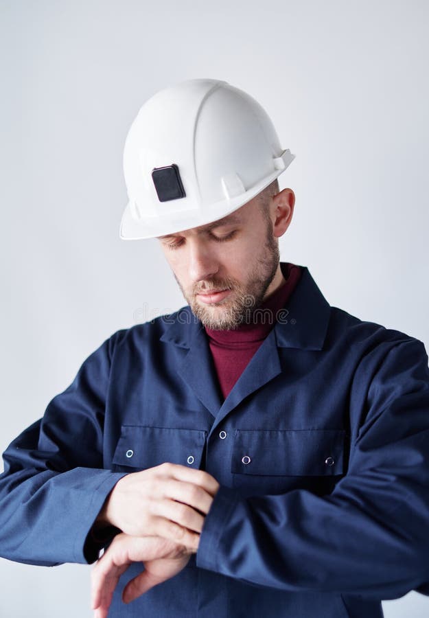 Building Concept: Engineer in Uniform and Helmet Checking Time Stock ...