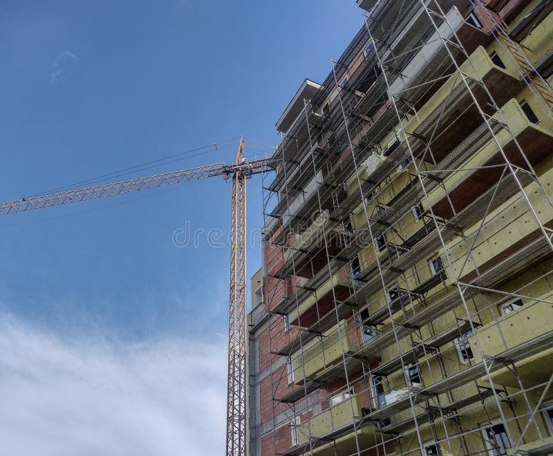 A Building during Construction and a Crane Next To it. Construction ...
