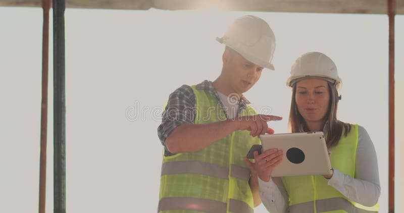 Building in Construction with a Female and a Male Builders ...