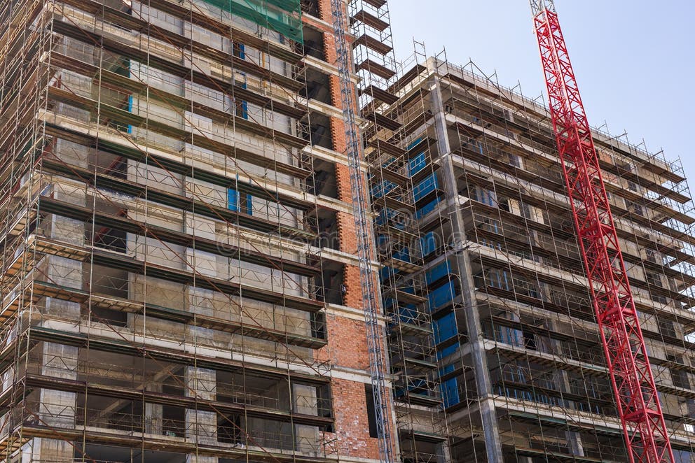 Building Crane and Building Under Construction Against Blue Sky Stock ...