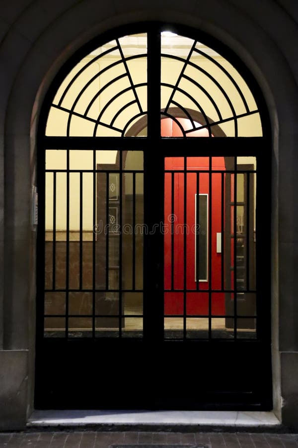 Building Door with Metalized Abstract Grill and Red Elevator in the ...