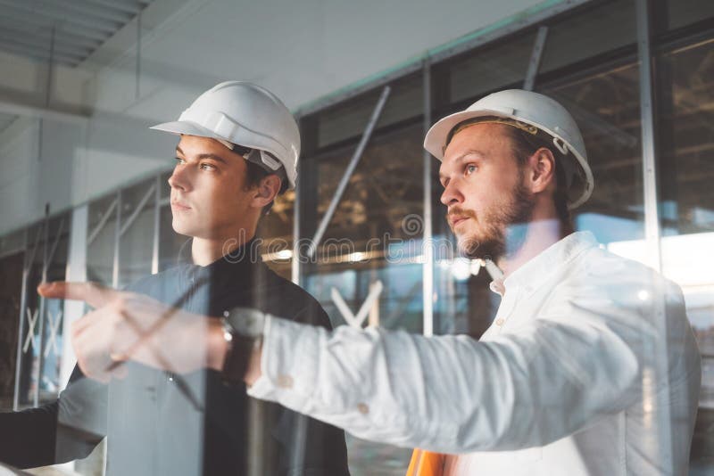 Building Engineer and Worker Hold Blueprint in Hand while Discussing ...