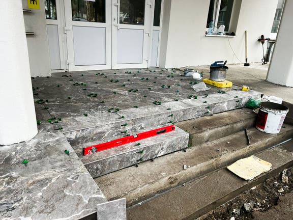 Tile Installation in Progress at a Building Entrance with Construction ...