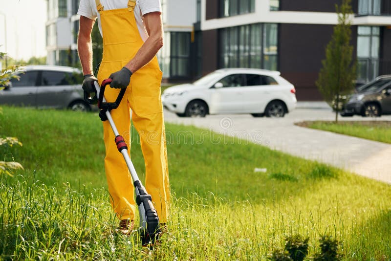 Building Exterior at Background. Man Cut the Grass with Lawn Mover ...