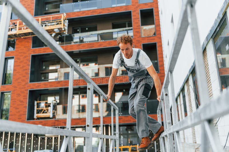 Building Exterior. Young Man Working in Uniform at Construction at ...