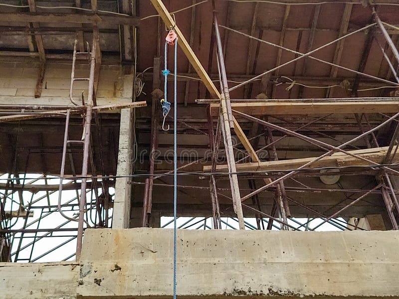 Building Framework with Visible Scaffolding, Rope Systems, and Signs of ...