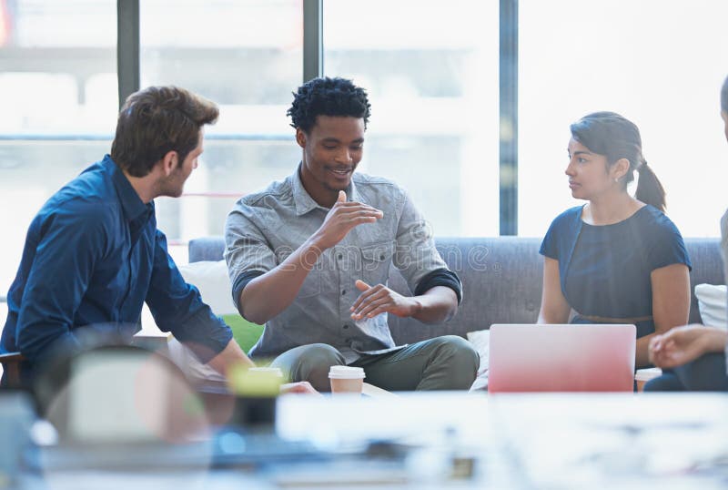 Building on His Ideas. a Group of Office Workers Talking Together in a ...
