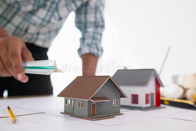 Building Models and Blueprints are Placed on Work Desks in the ...