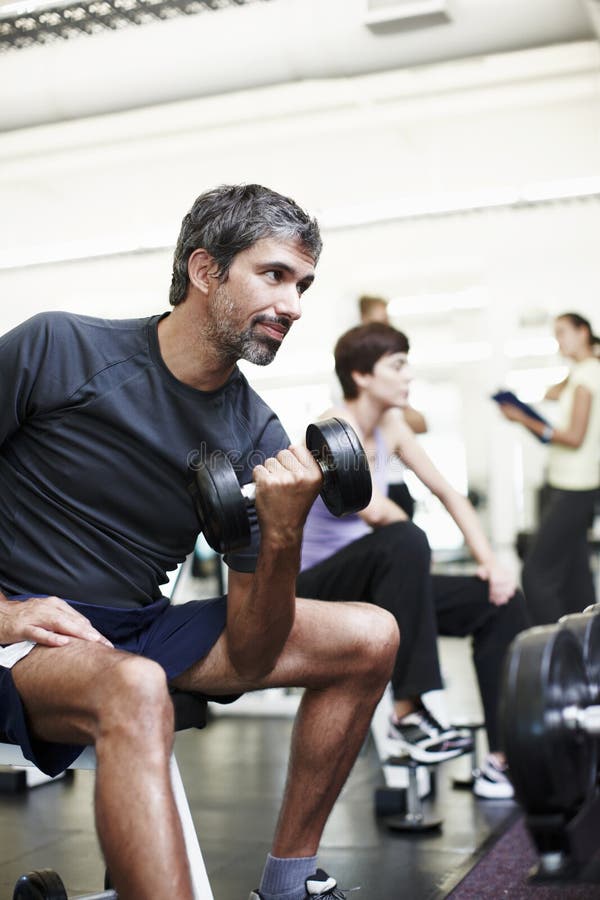 Building Muscle. a Handsome Man Working Out with Weights in the Gym ...