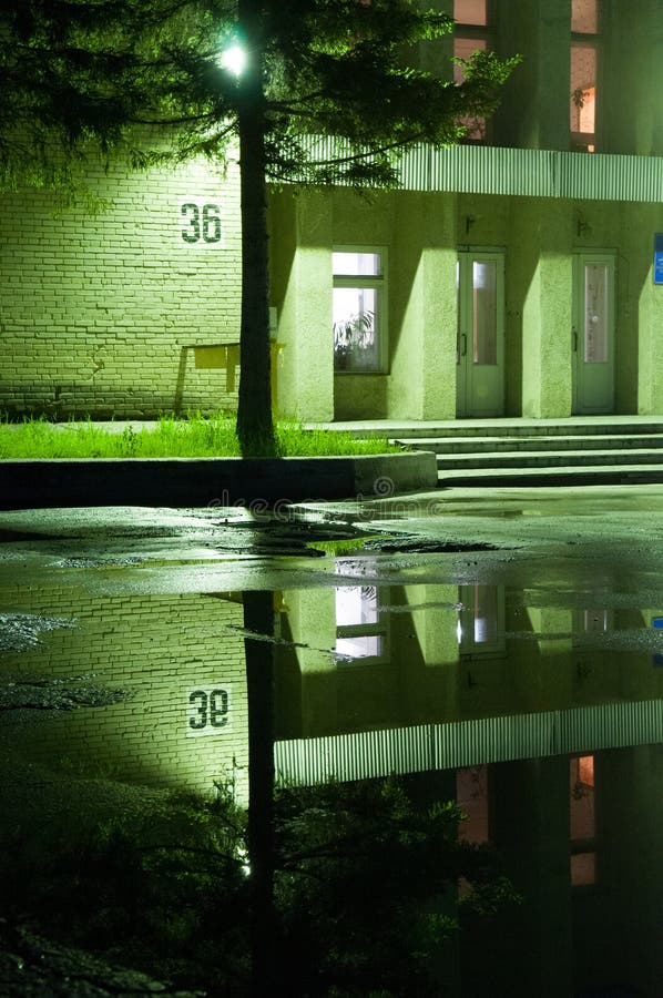 Building in the Night with Reflection in a Puddle Stock Photo - Image ...