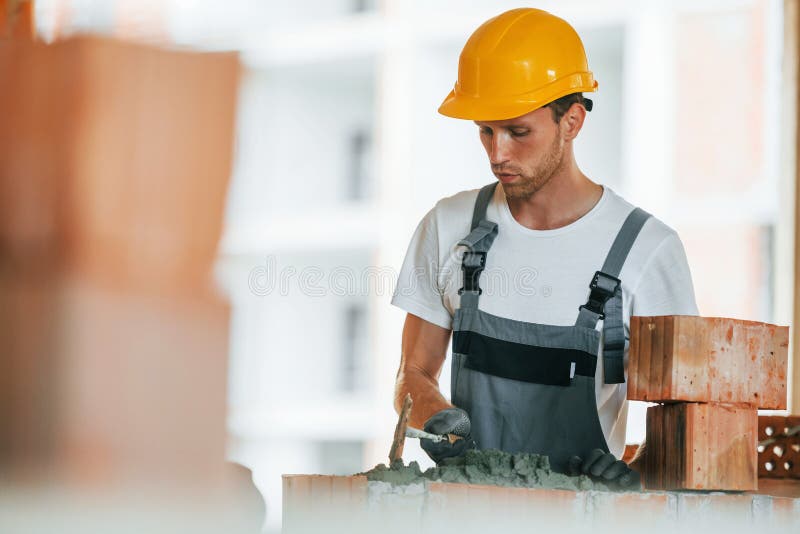 Building Process. Young Man Working in Uniform at Construction at ...