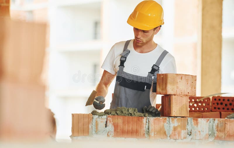 Building Process. Young Man Working in Uniform at Construction at ...