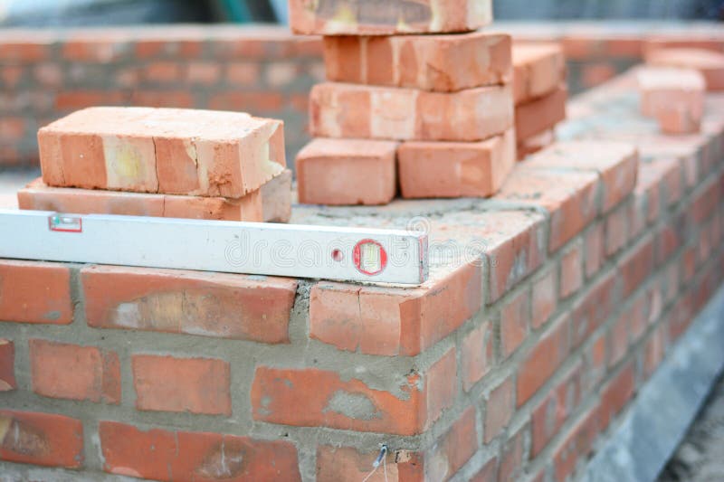 Building Red Brick House Wall with Spirit Level and Pile of Bricks ...