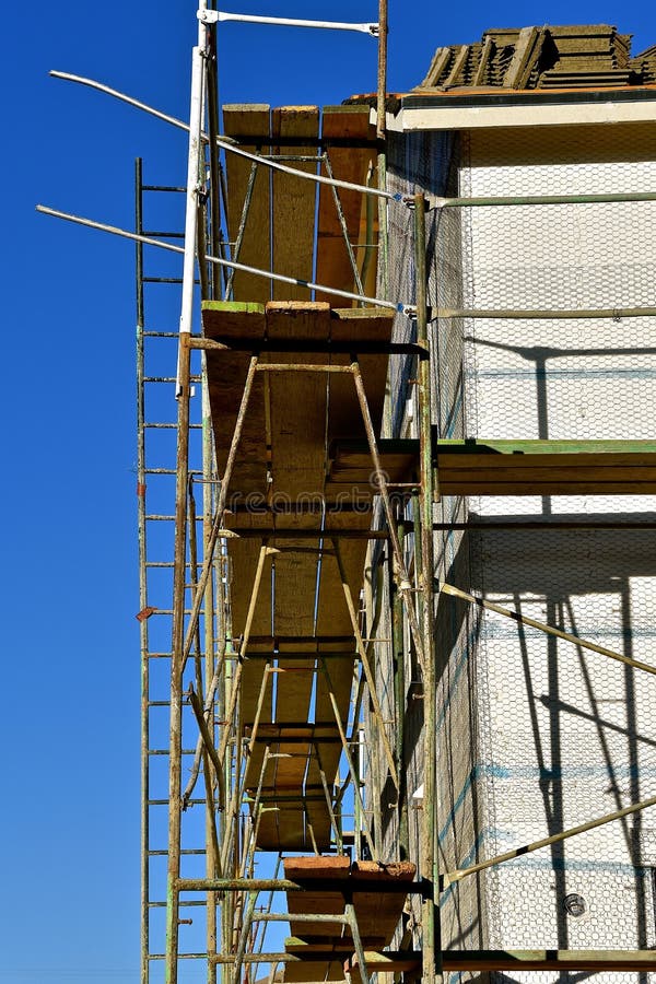 Side Profile of a House Under Construction with Scaffolding and Tile ...