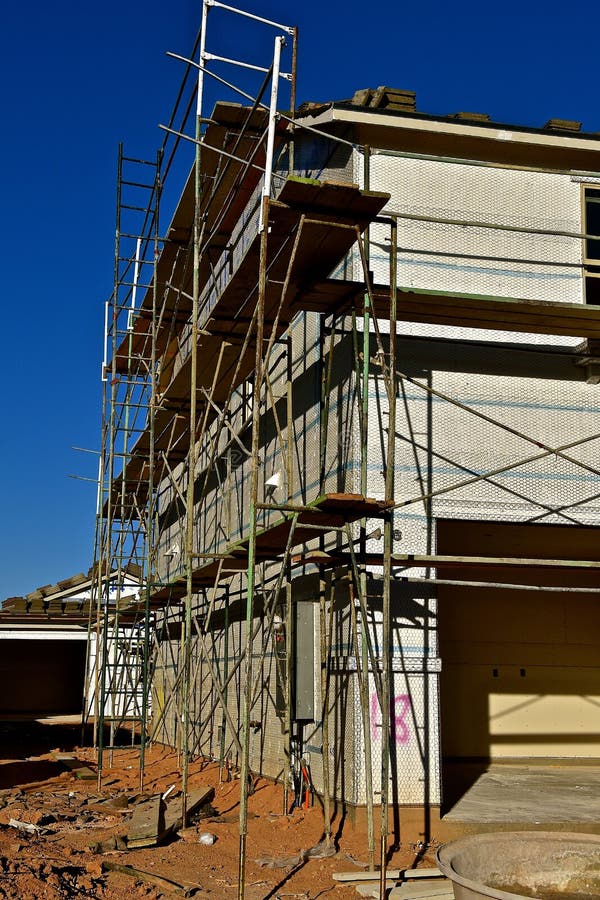 Side Profile of a House Under Construction with Scaffolding and Tile ...