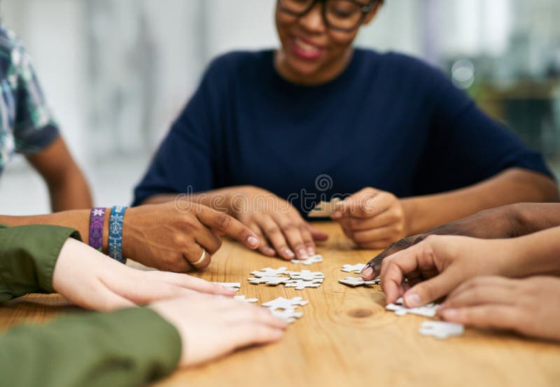 Building Success Together. Shot of a Group of People Building a Puzzle ...