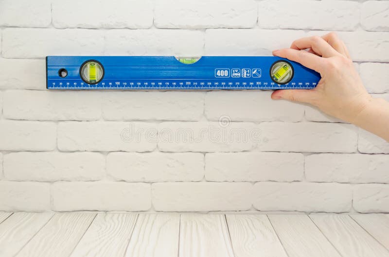 Building Tool, Blue Metal Level in Female Hand on Background of a White ...