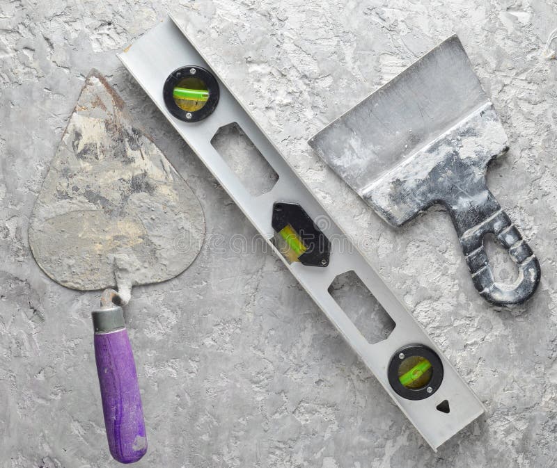 Building Tools on a Gray Concrete Background. Spatula, Trowel, Level ...