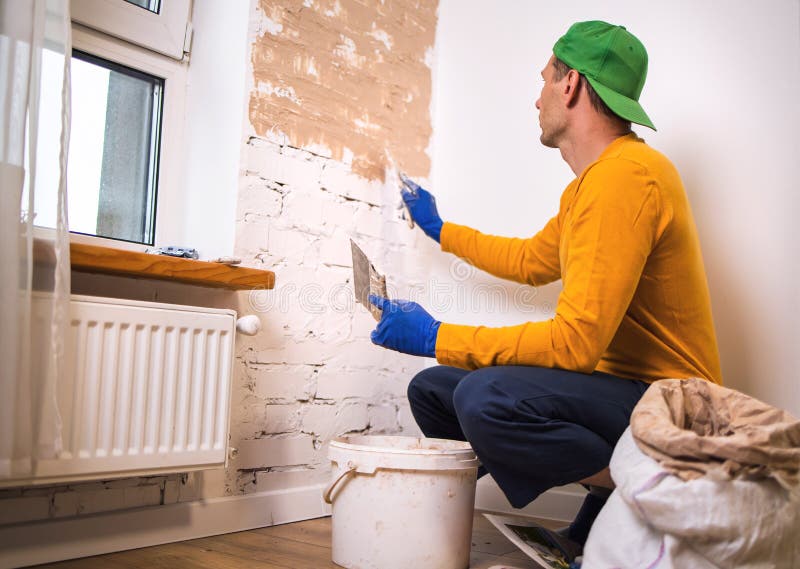 Building Under Construction with Bricklayer Plastering Concrete To ...