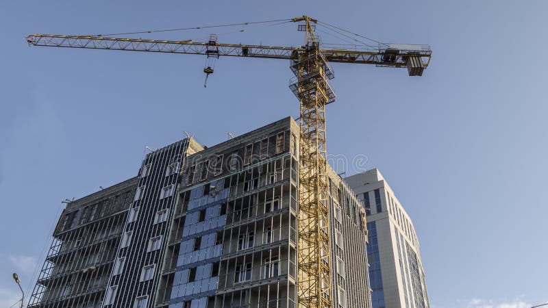 Building Under Construction and Crane Standing Next To Stock Image ...