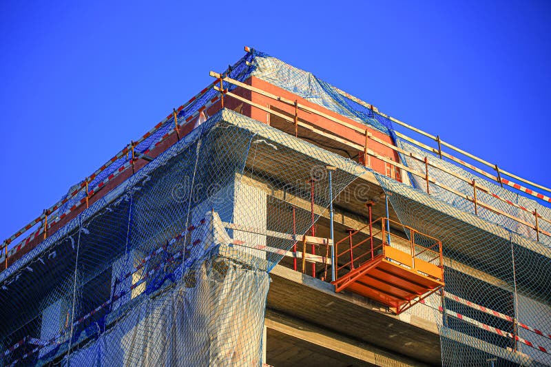 Building Under Construction with Safety Netting, Scaffolding, and an ...