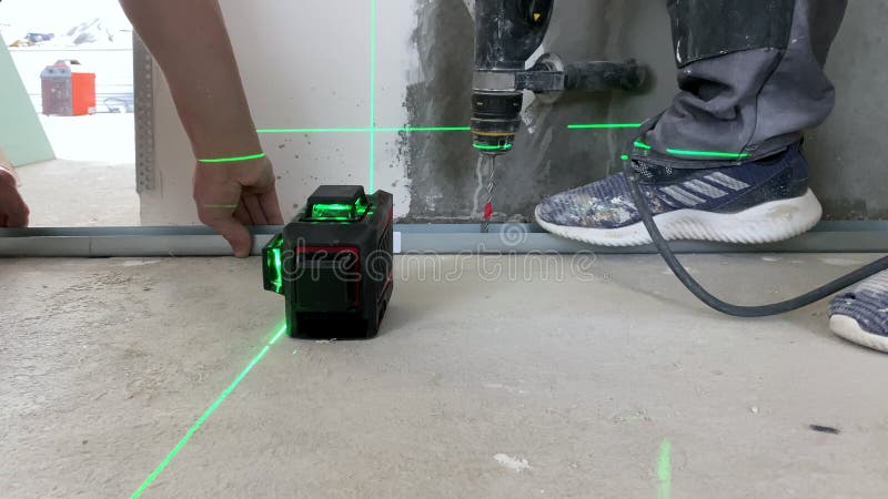 Building Worker Setting Modern Laser Level on the Floor on Construction ...