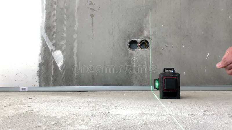 Building Worker Setting Modern Laser Level on the Floor on Construction ...