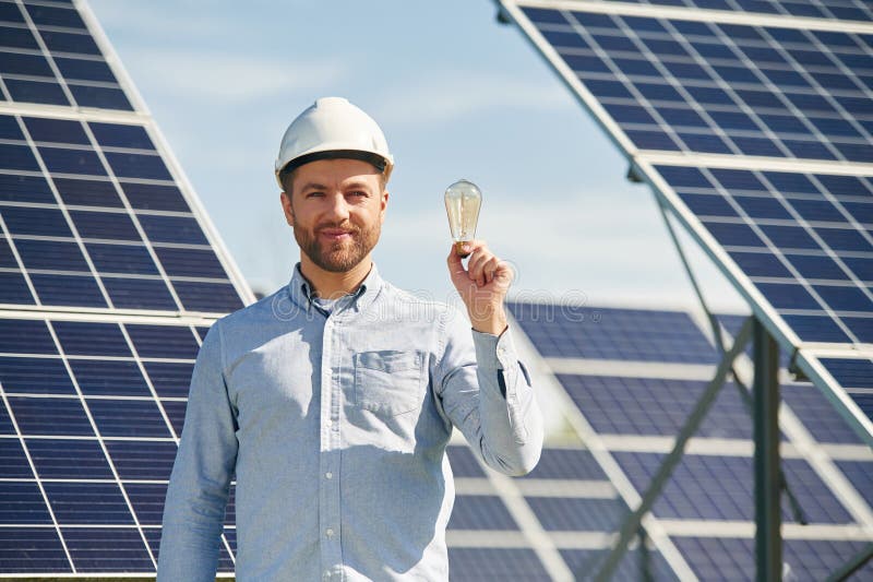 Bulb in Hand. Engineer with Photovoltaic Solar Panels Outdoors at ...
