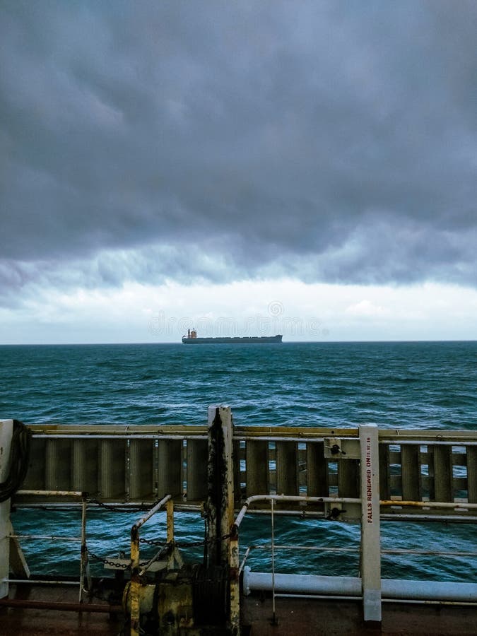 A Bulk Carrier Ship Passing Under Heavy Rain Clouds and Storm Clouds ...