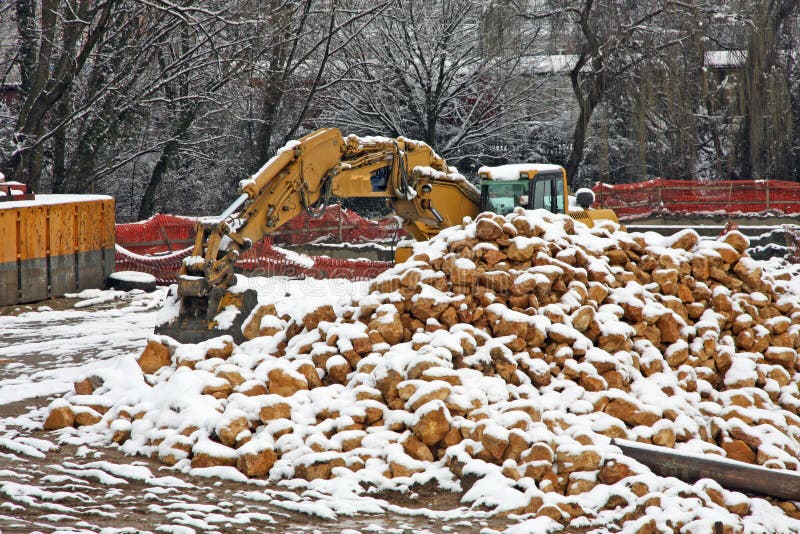 Bulldozer Digger during the Work with Many Rocks and Lots of Fresh Snow ...