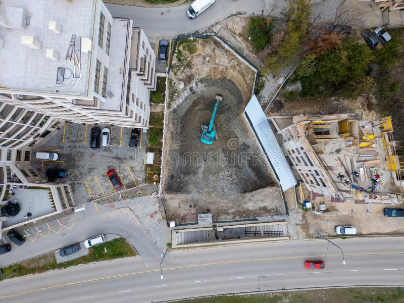 A Bulldozer is Digging a Pit for the Construction of Another Building ...