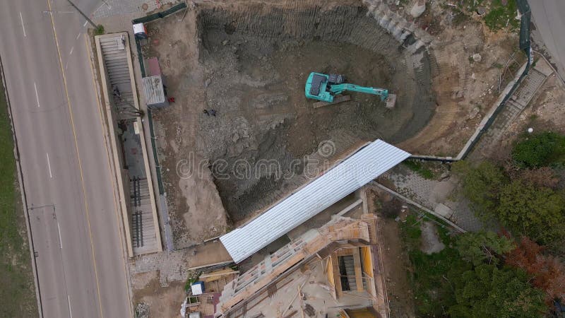A Bulldozer is Digging a Pit for the Construction of Another Building ...