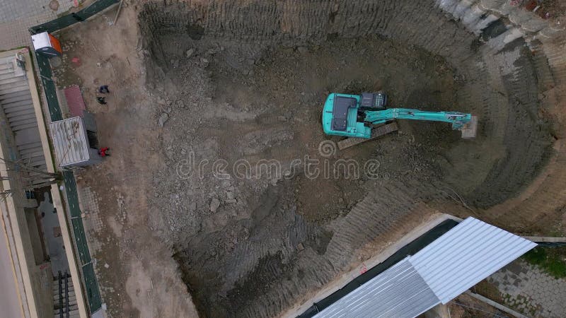 A Bulldozer is Digging a Pit for the Construction of Another Building ...